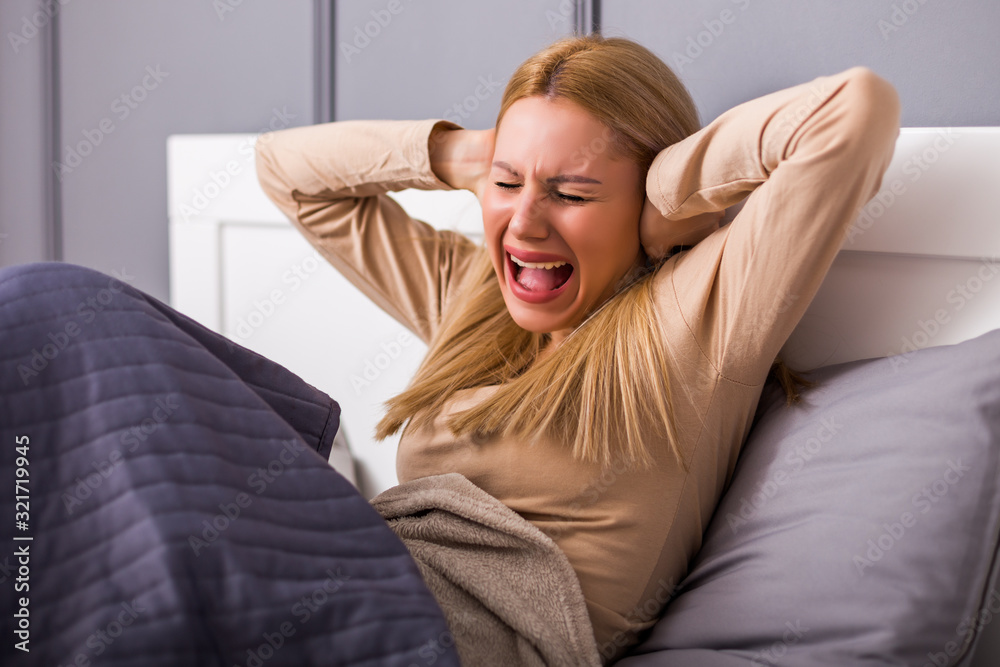 Angry woman disturbed with a noise having problems with sleeping. Stock ...