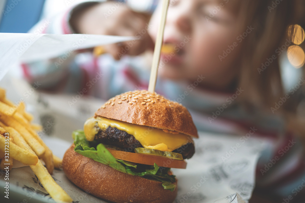 child eats a mini Burger and fries. children's menu in the cafe Stock ...