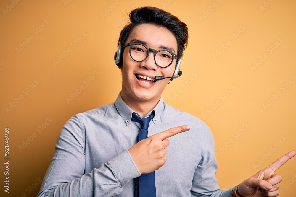 Young handsome chinese call center agent man wering glasses using ...