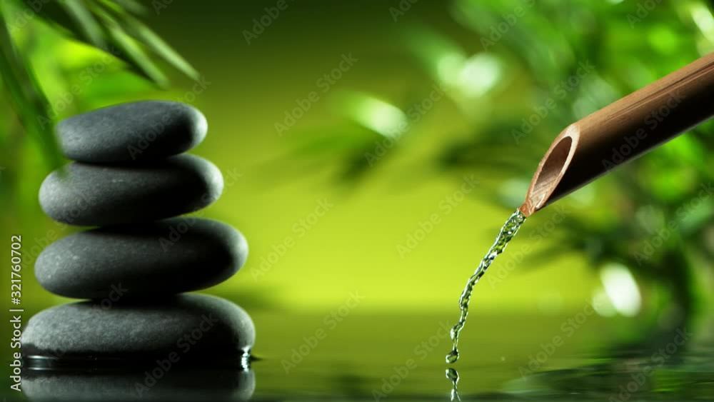 Super slow motion of leaking water stream from bamboo, spa and wellness ...