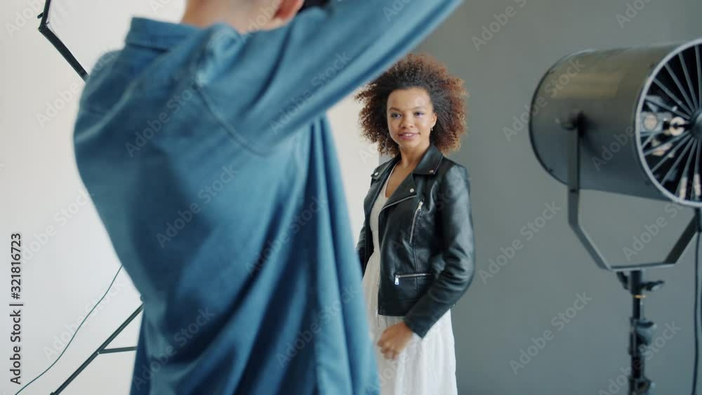 Vidéo Stock Beautiful mixed race model posing for photographer who is ...