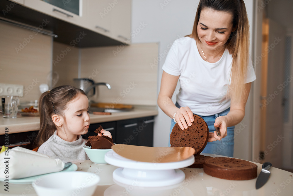 hardworking woman and her child making tasty cake for her husband ...