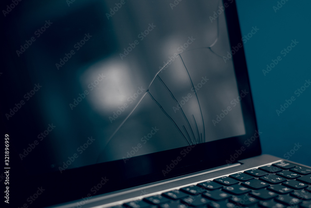 The screen laptop cracked and damaged. A silver laptop with a broken ...