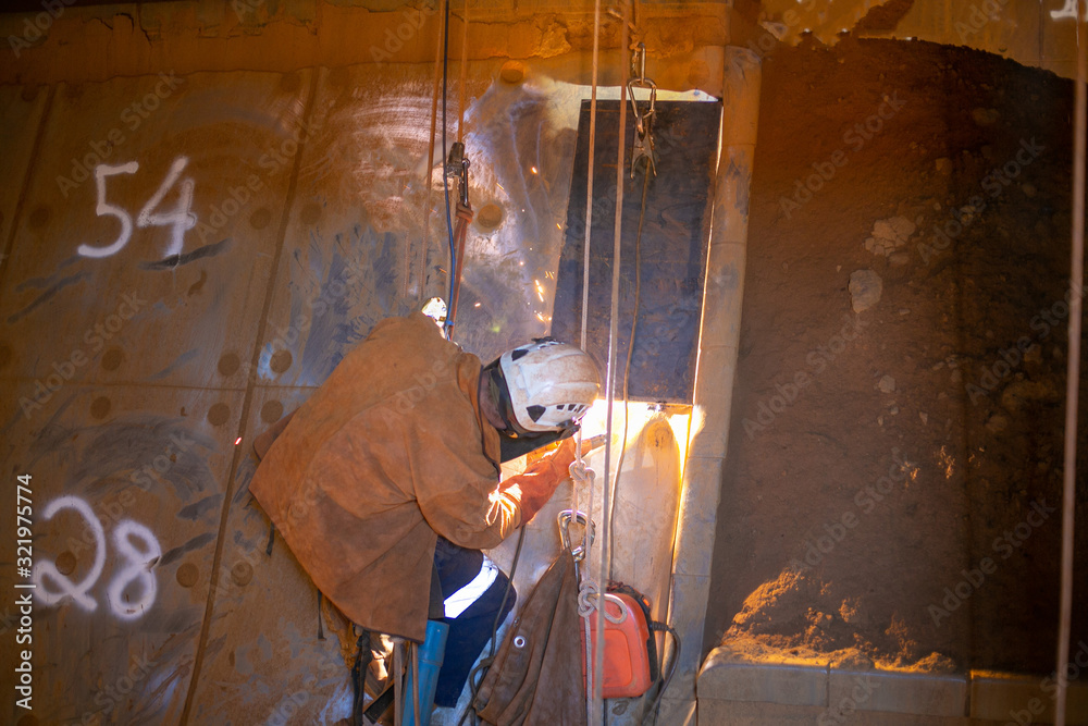Close up shot rope access abseiler stick welder working at height ...