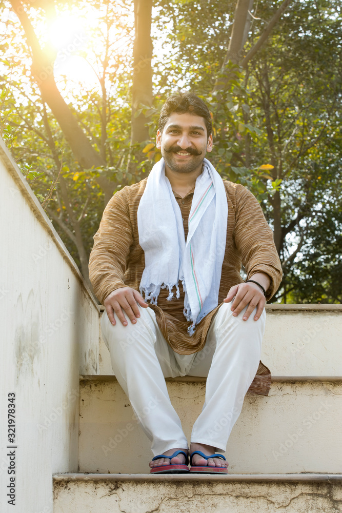 Smiling village man sitting on the steps of his house leading to the ...