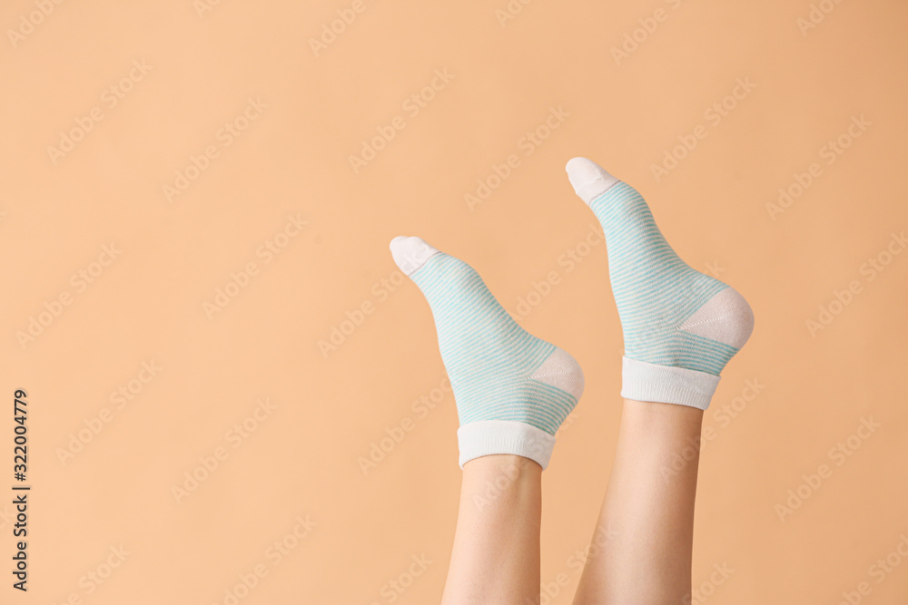 Legs of young woman in socks on color background Stock Photo | Adobe Stock