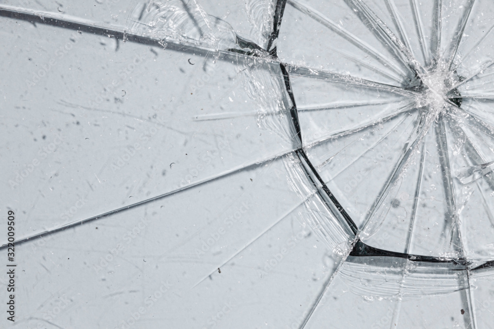 A shattered glass on a light surface, ripped in big pieces like a ...