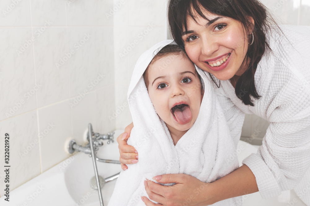 Mom and daughter after bath. Little baby jeer her mother. Child in a ...