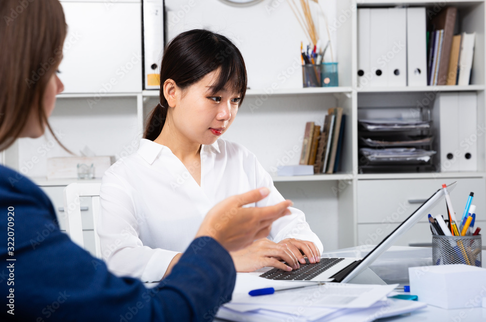 Asian woman working with client Stock Photo | Adobe Stock