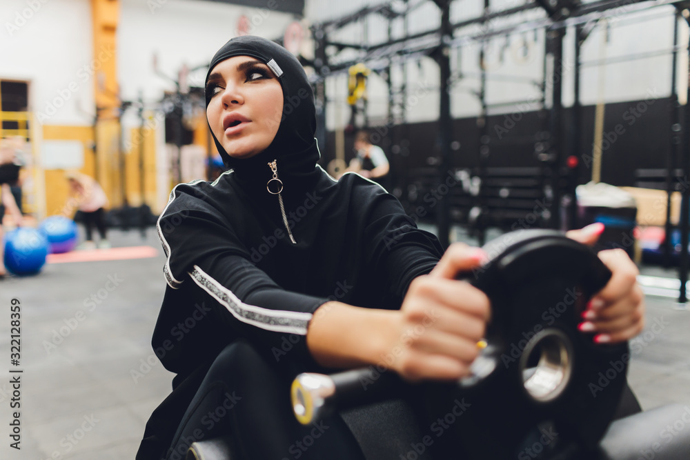 Muslim asian woman in hijab exercizing in a gym. Stock Photo | Adobe Stock