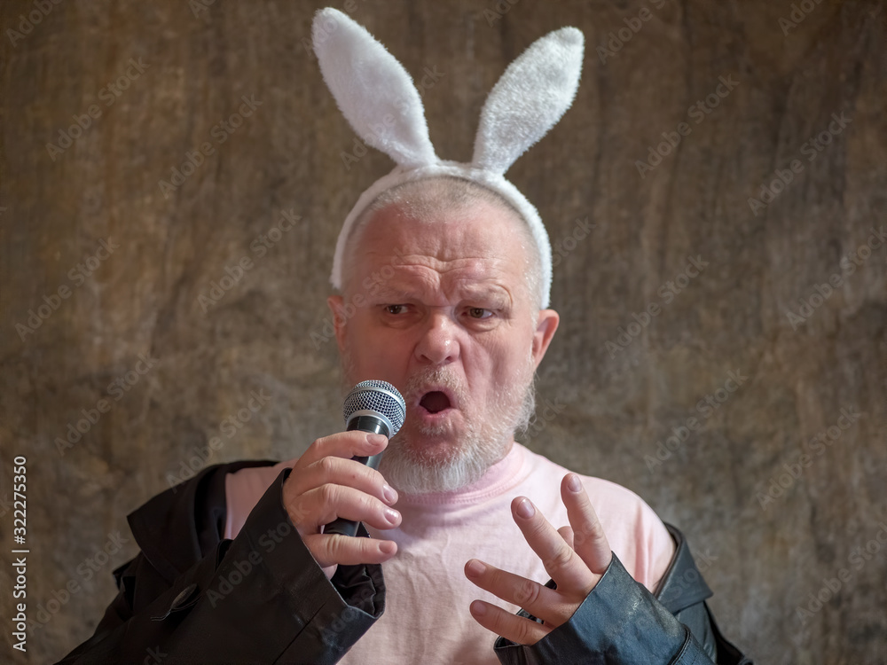 elderly man in pink pajamas, rabbit ears and leather coat of exhibition ...