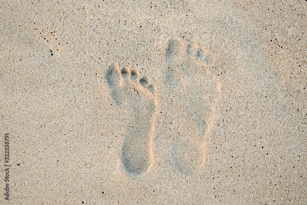 footprints in the sand of different sizes for comparison on the beach ...