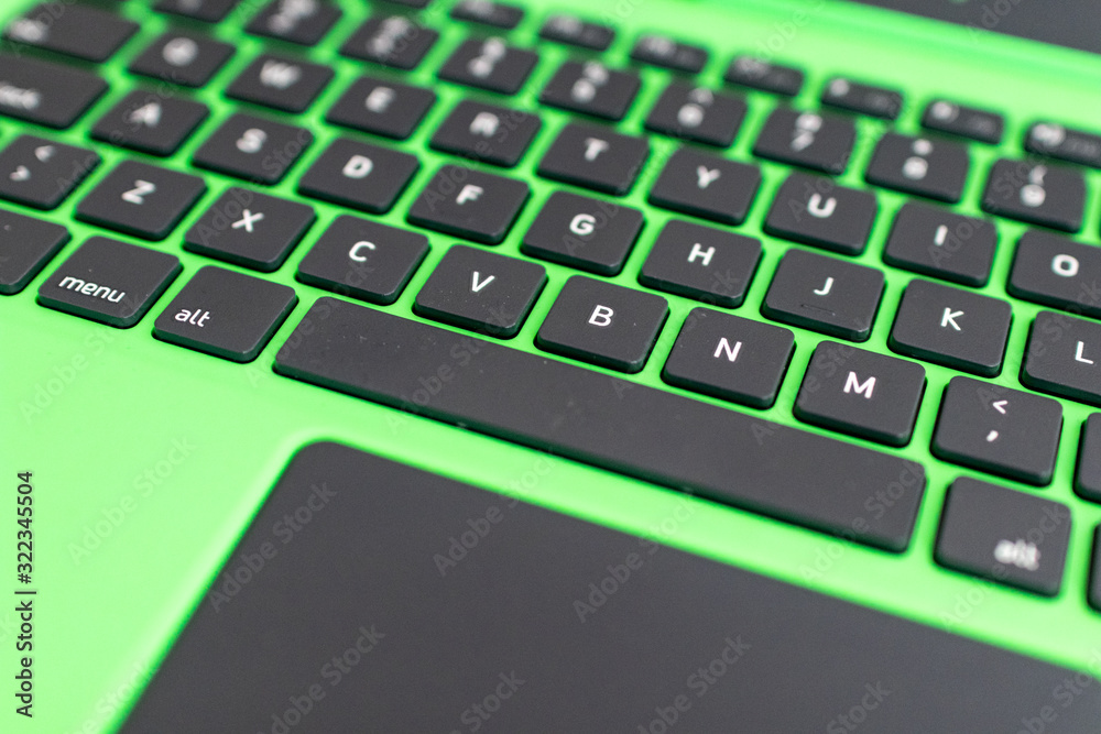 black keyboard on a green laptop. keys with letters and numbers. Detail ...
