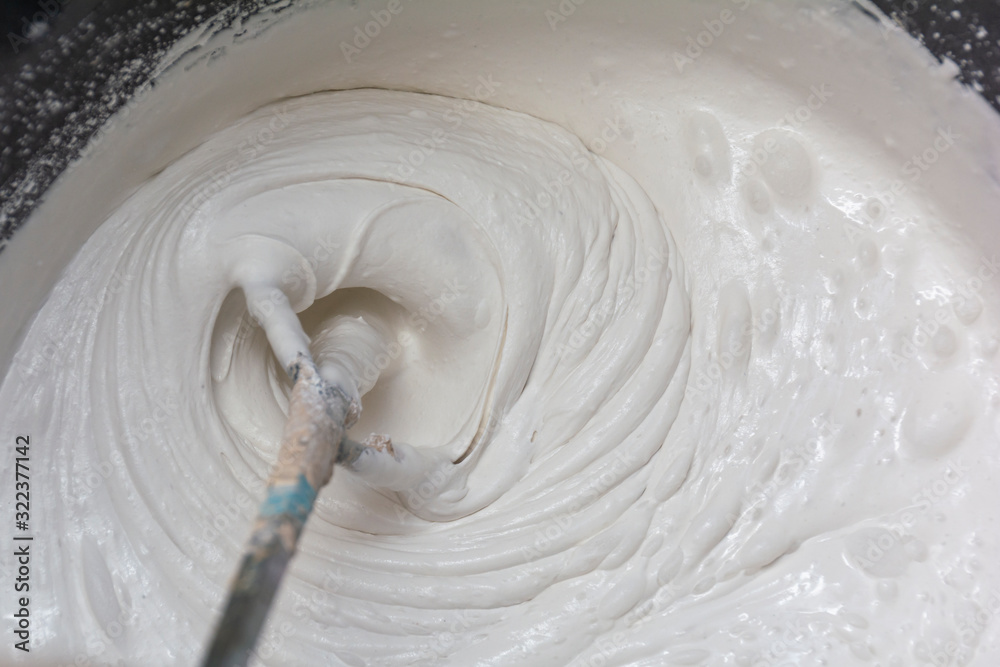 Building mixture in the process of preparation. A worker mixes the ...