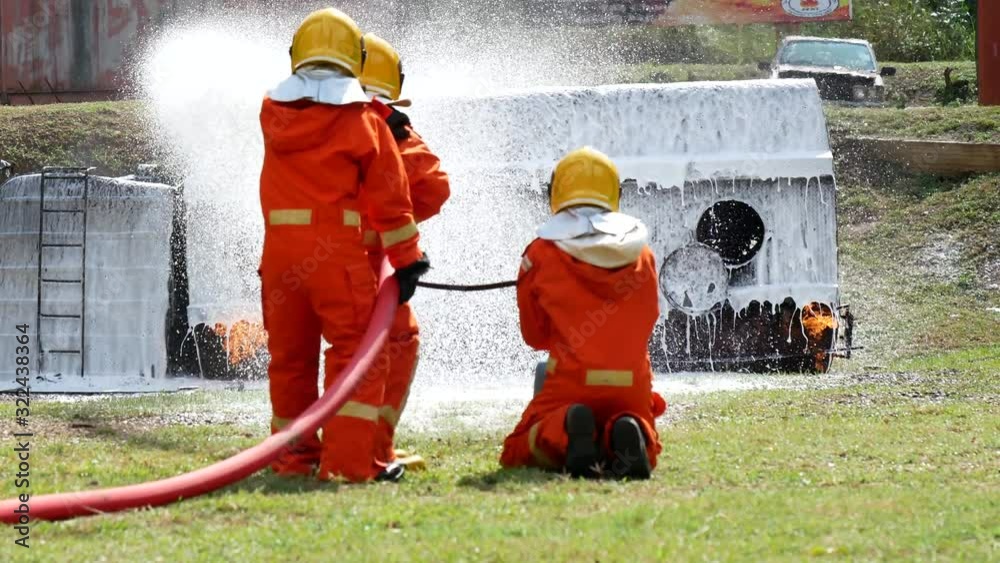 Firefighter fighting with fire flame protection property. Fireman wear ...