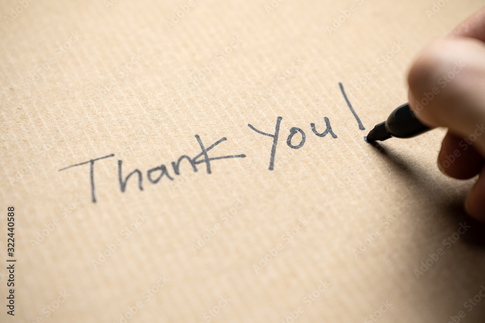 Hand writing thank you note on brown color paper Stock Photo | Adobe Stock