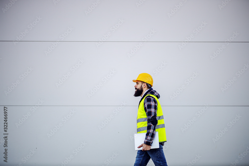 Side view of hardworking construction worker with safety helmet on head ...