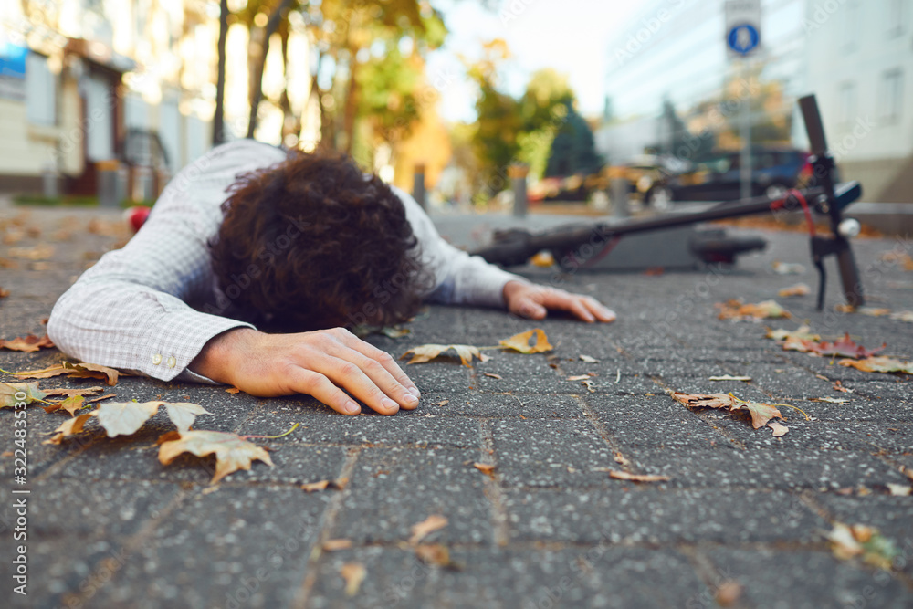 Accident with an electric scooter. A man fell from a scooter on a city ...