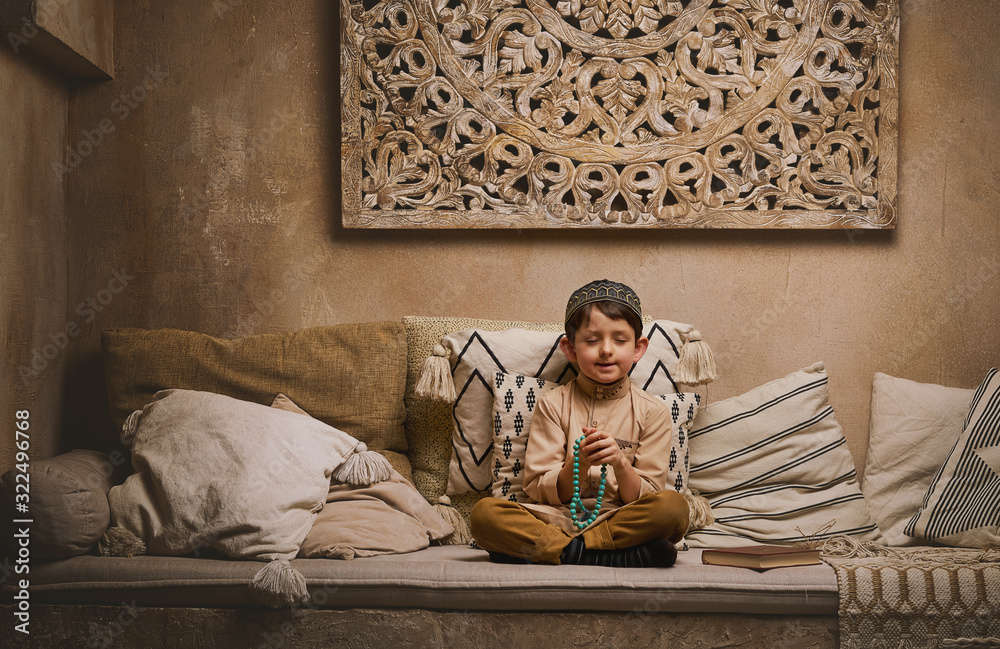 Foto de Little muslim boy in prayer cap and arabic clothes with rosary ...