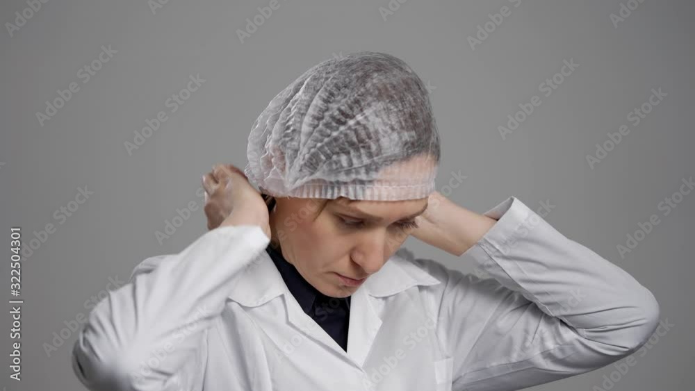 female doctor is putting protective cap on head in clinical office ...