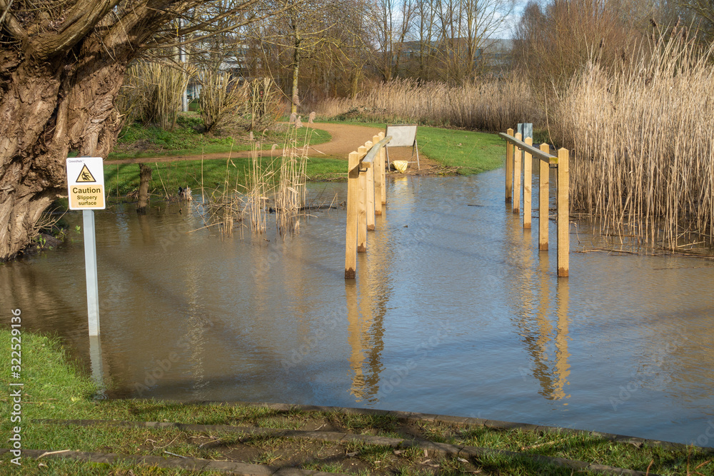 A walkway is submerged as a lake has flooded and submerged the pathway ...