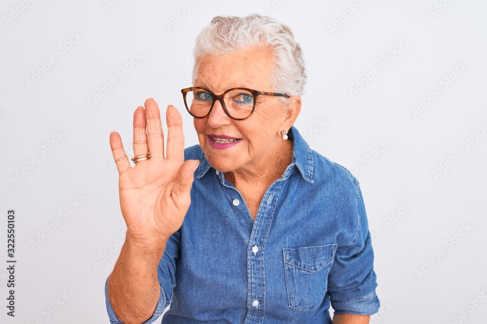 Senior grey-haired woman wearing denim shirt and glasses over isolated ...