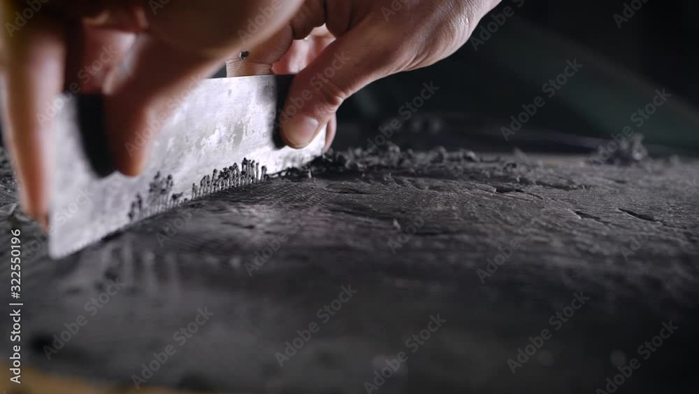 A close-up of a man's hand with a tool. A professional removes the form ...