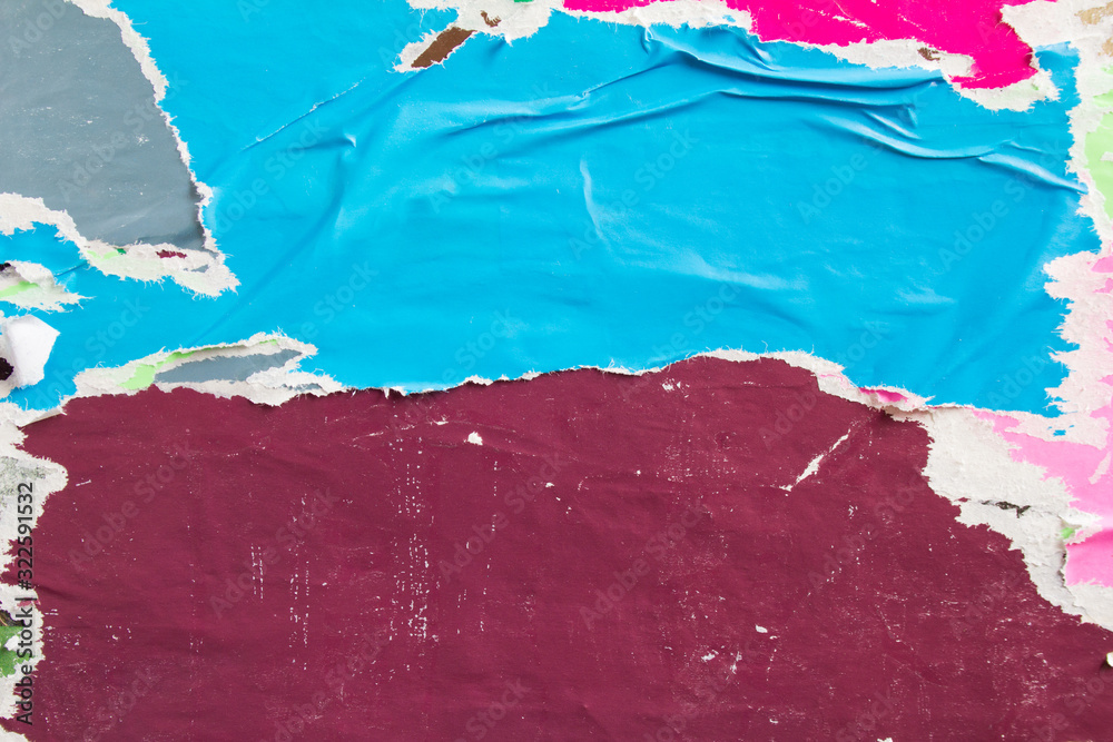 Blue and purple torn peeling and crumpled paper placards on billboard ...