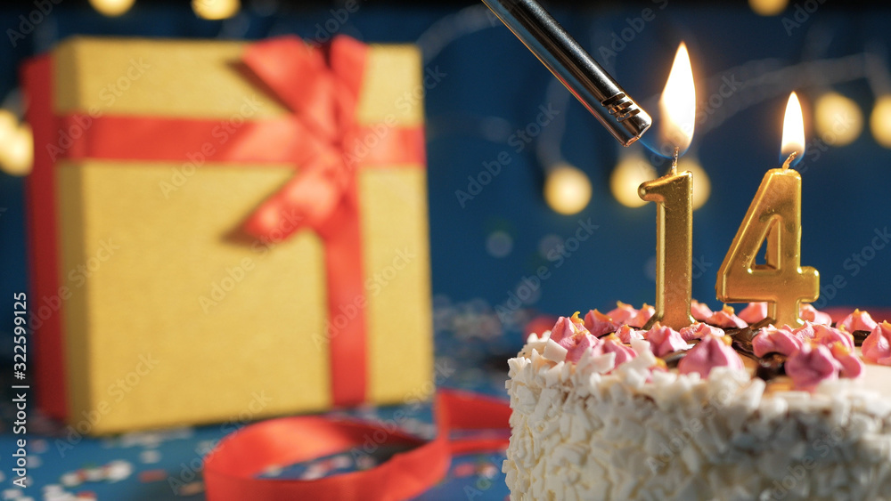 White birthday cake number 14 golden candles burning by lighter, blue ...