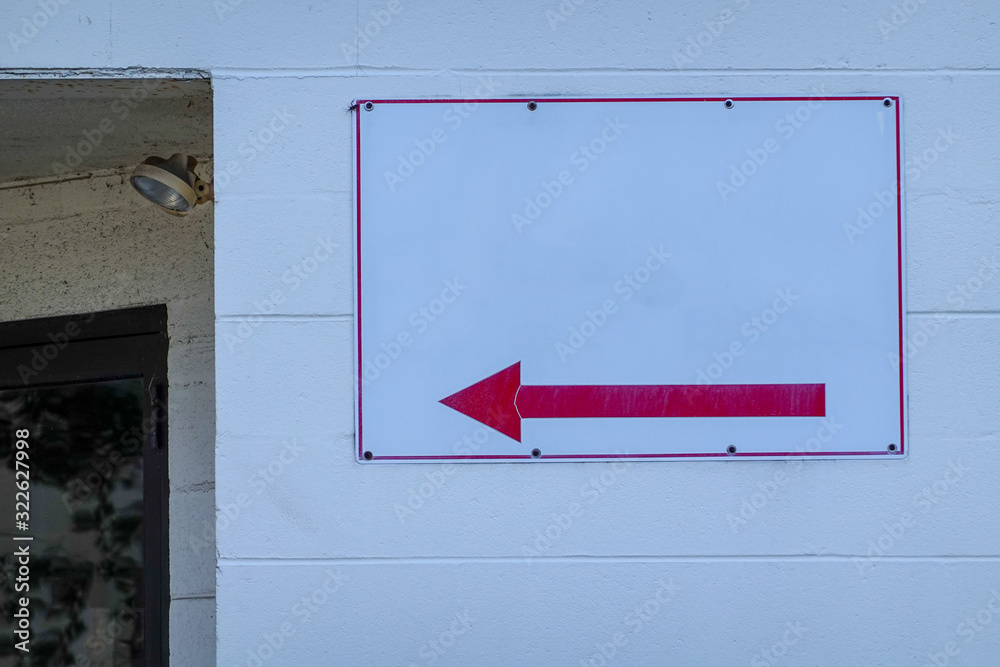 Blank white sign with a red arrow on a white cinder block wall Stock ...
