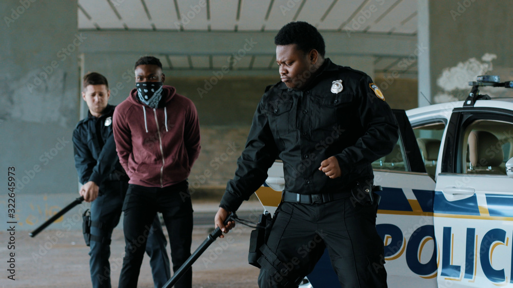 Dance time two policemen are standing near the car with a african ...