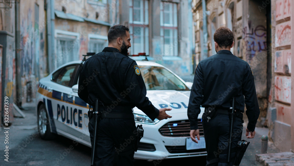 Two young men cops sit in patrol car walk pistol run enforcement happy ...