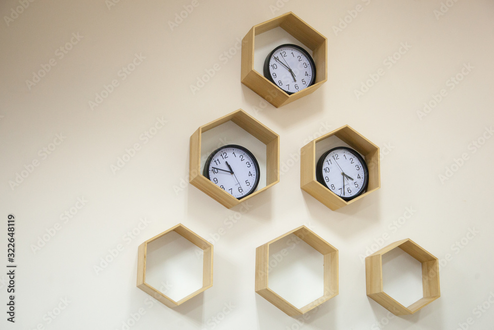 Clocks with different timezones on the wall in the wooden shelves in IT ...