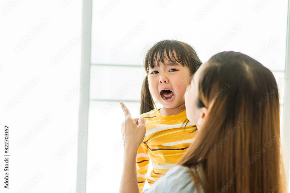 Stressed exhausted mother holding daughter crying and sadly.Little girl ...