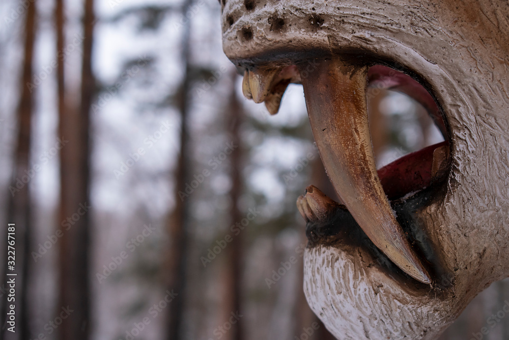 Face of a predatory beast in profile. Large upper fangs and teeth ...
