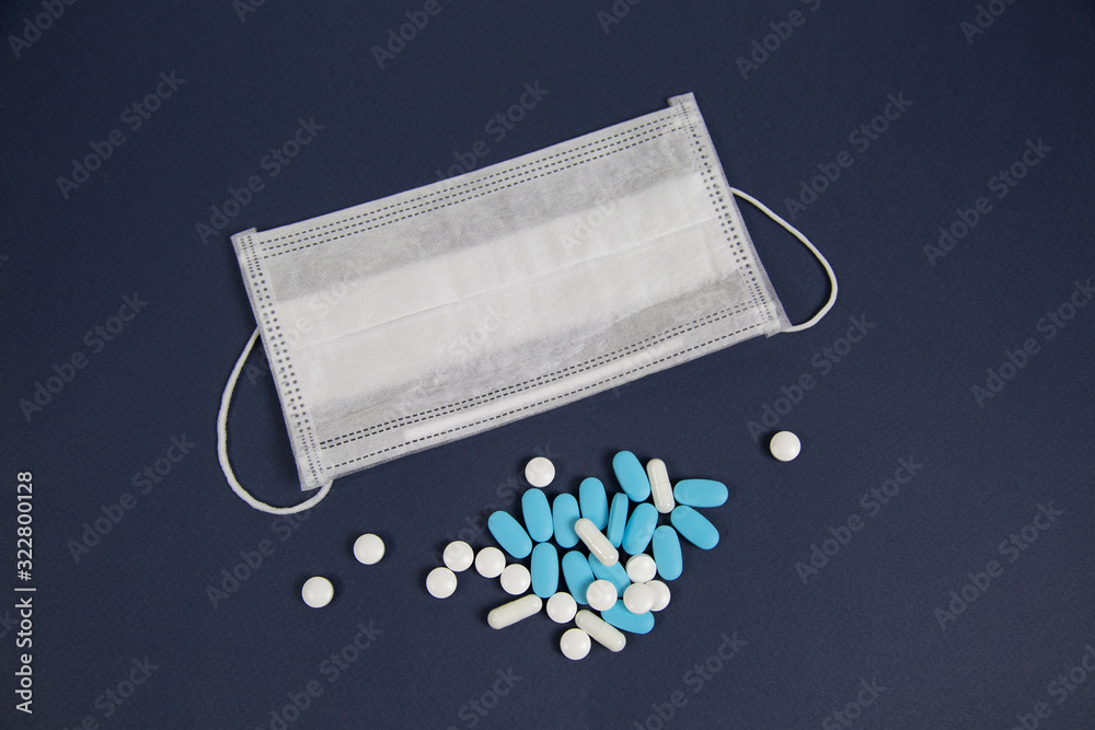 Medical face mask white pills blue and white on a lilac background ...