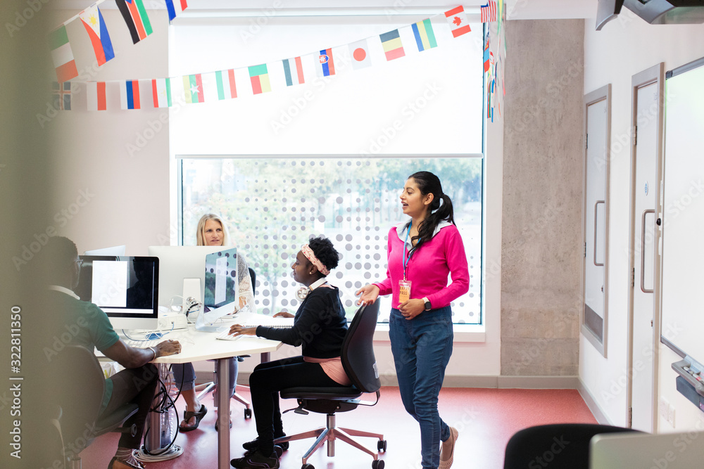 Community college instructor leading lesson in computer lab classroom ...