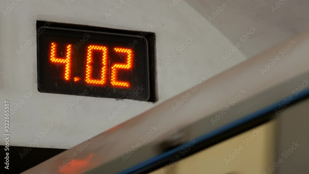 The metro train enters the subway tunnel under the electronic clock ...