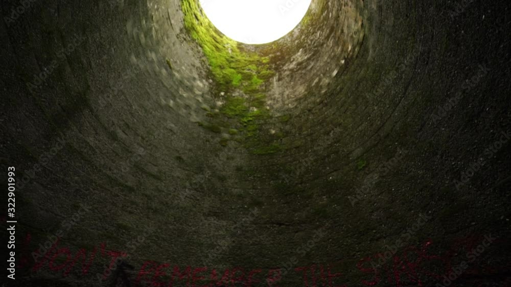 Slow Pan down, of an abandoned silo seen from the inside, dark murky ...