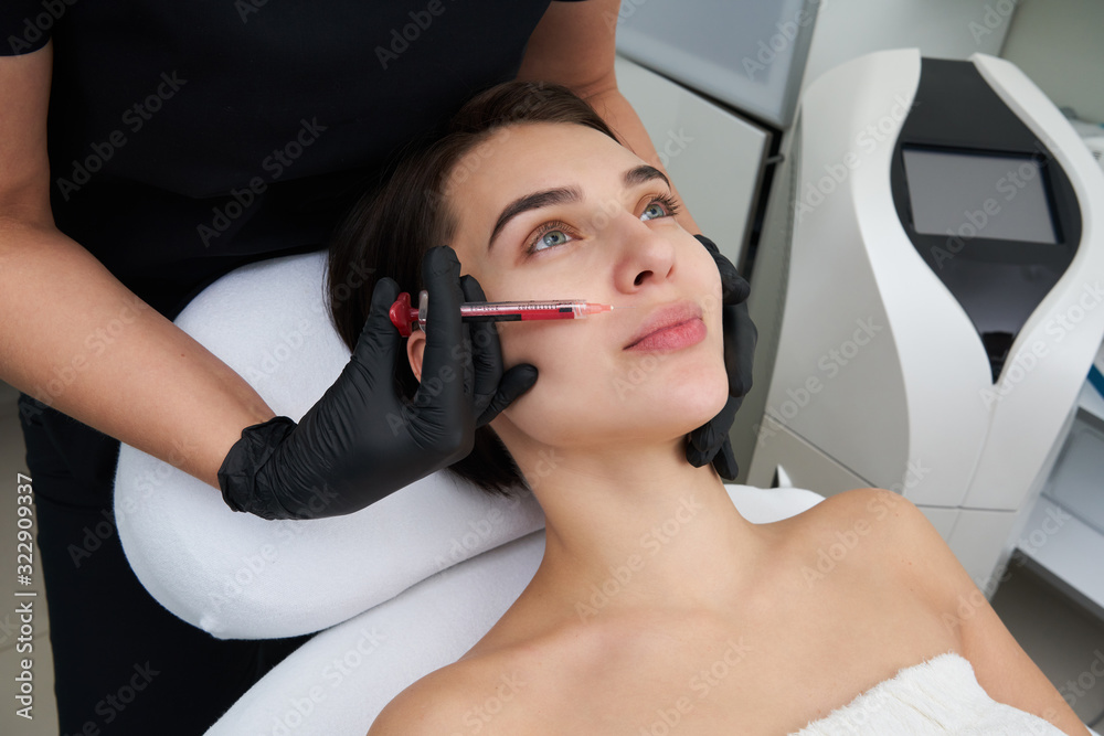 Beautiful woman gets an injection in her lips Stock Photo | Adobe Stock