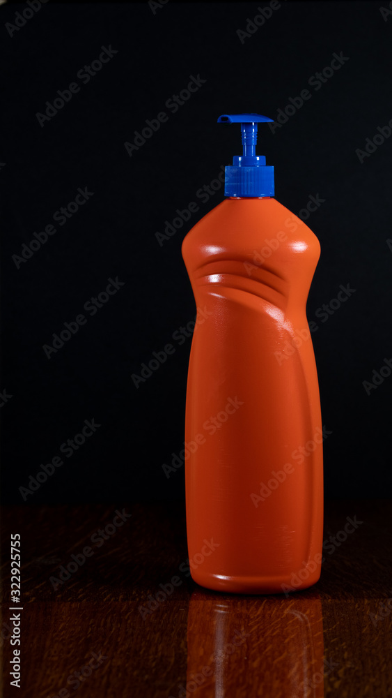 Orange bottle of detergent. Bottle without labels and name. Hand ...