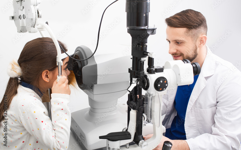 Male doctor looking very carefully at screen of ophthalmic tonometer to ...