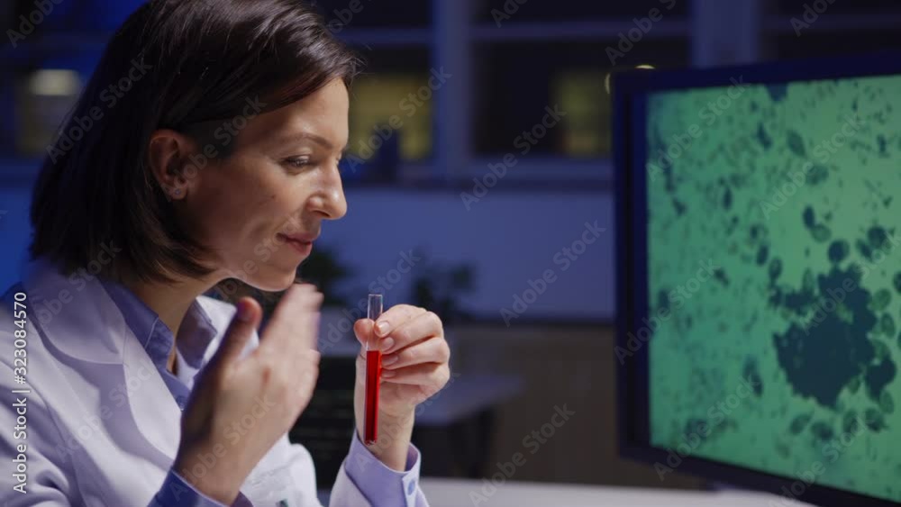 Side view zoom in of middle aged female biochemist in lab coat smelling ...
