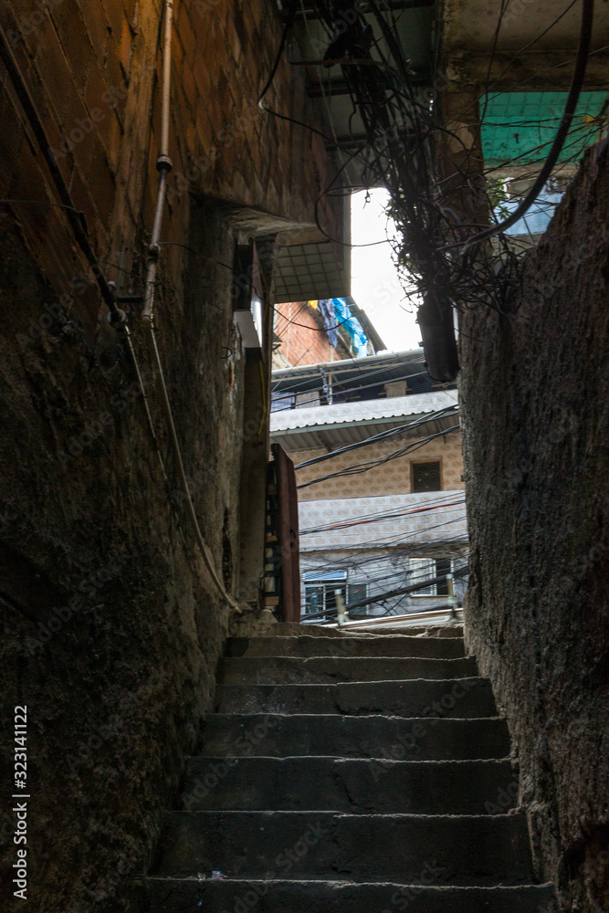 Steps leading up a dark & narrow alley into a street with buildings in ...