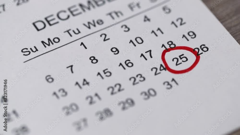 Female hand marks the date of December 25 with a red marker. On the ...