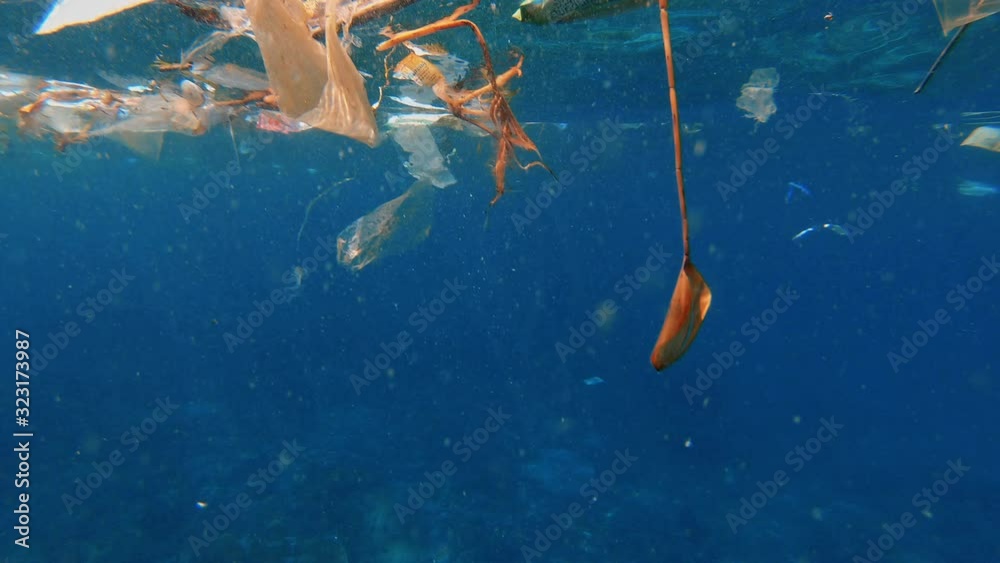 A young blonde girl swimming and diving in blue tropical sea water full ...