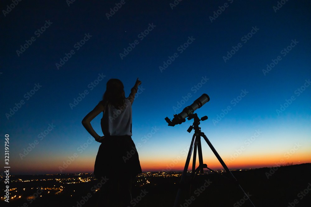 Astronomer with a telescope watching at the stars and Moon with blurred ...