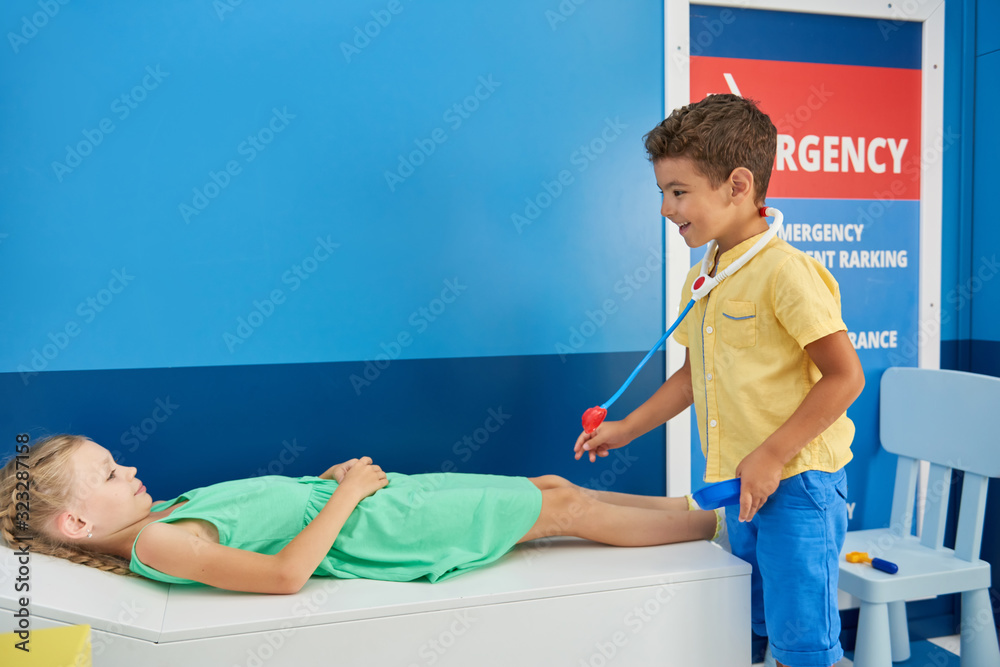 Children playing doctor and patient. Happy kids playing doctor in ...