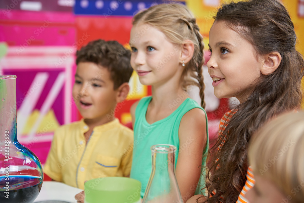 Happy children doing chemical experiments in playroom. Science show for ...