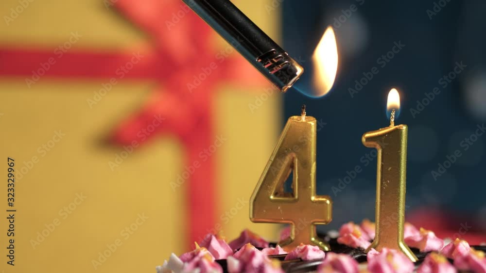 Birthday cake number 41 golden candles burning by lighter, blue ...